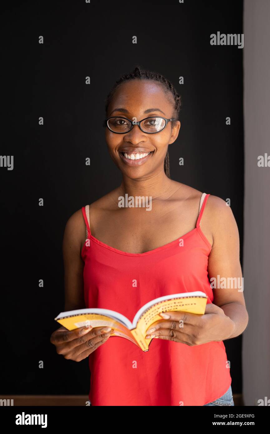 African American female with braided hairstyle and in glasses reading ...
