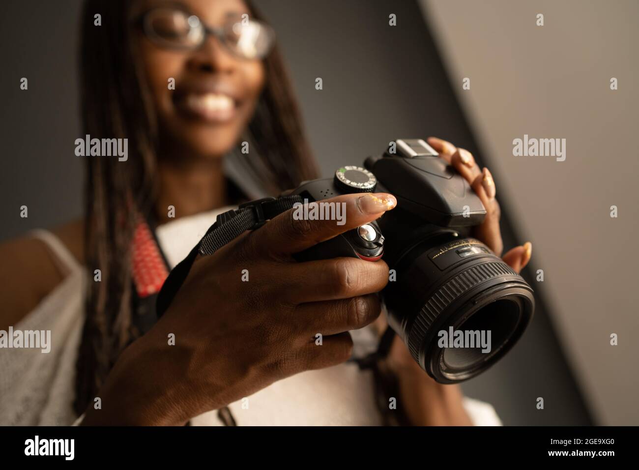 African American female photographer with braids looking through photos ...
