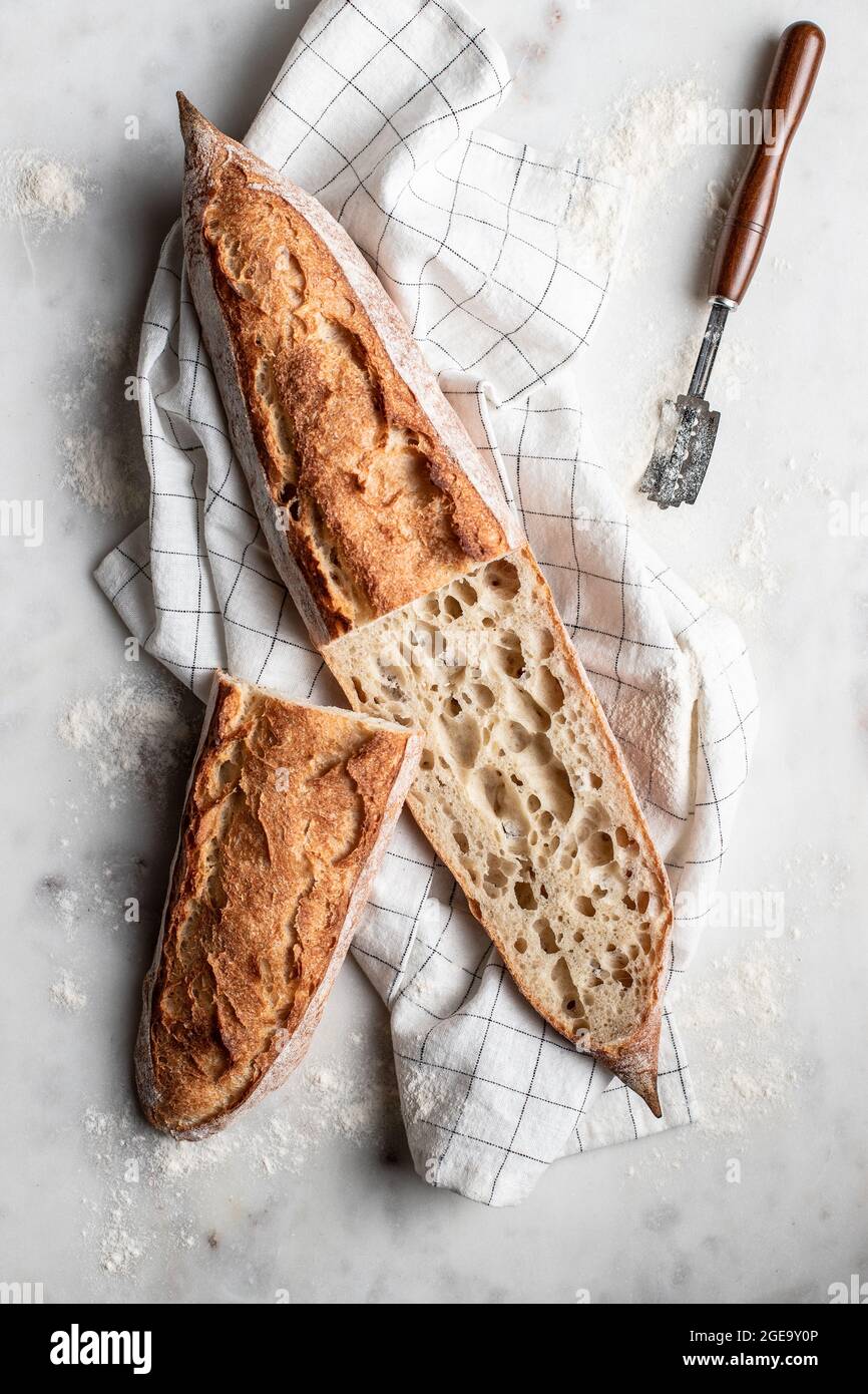 Top view of delicious homemade loaf of bread placed on cloth on marble ...