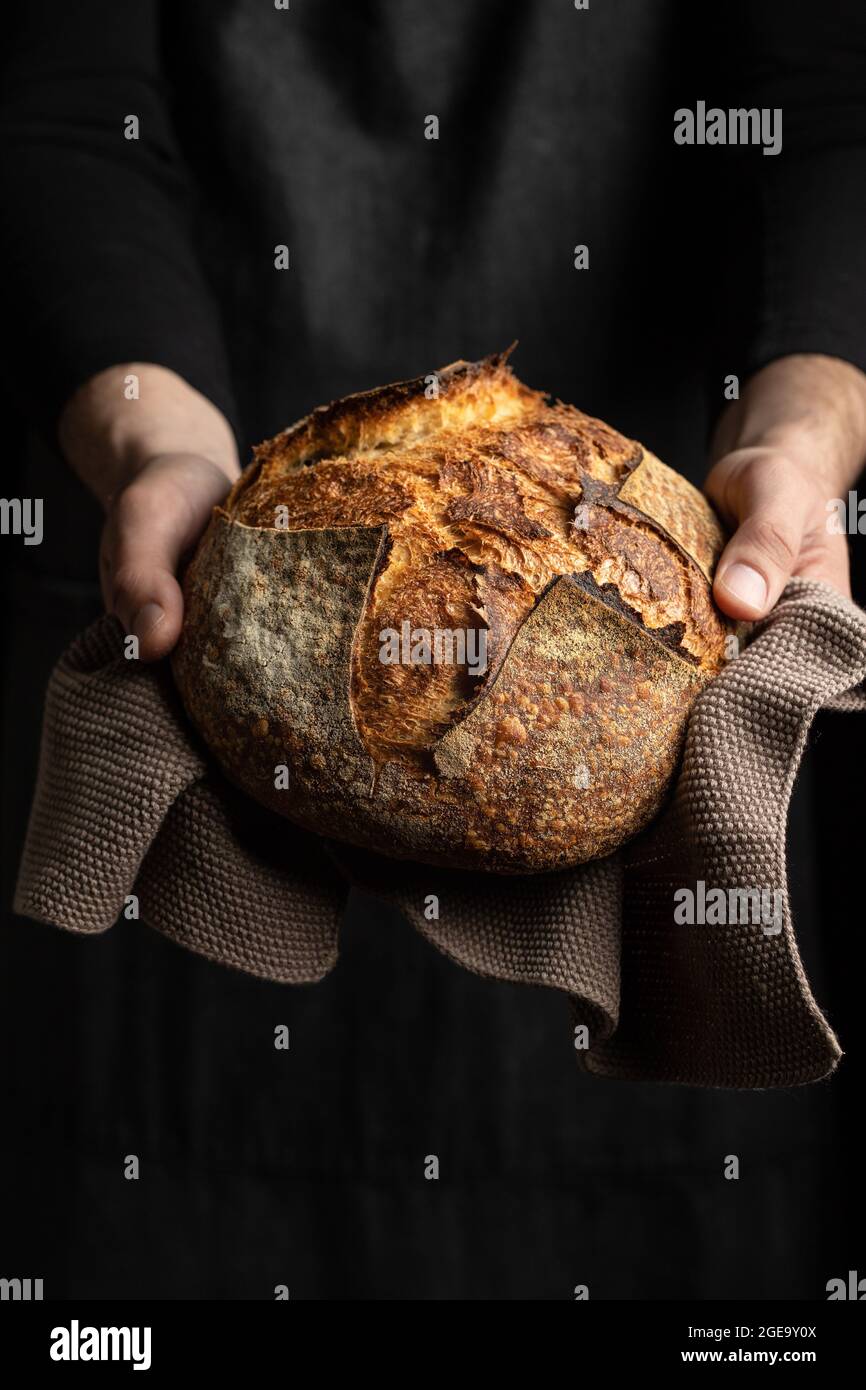 Unrecognizable crop chef in apron standing with piece of freshly baked ...