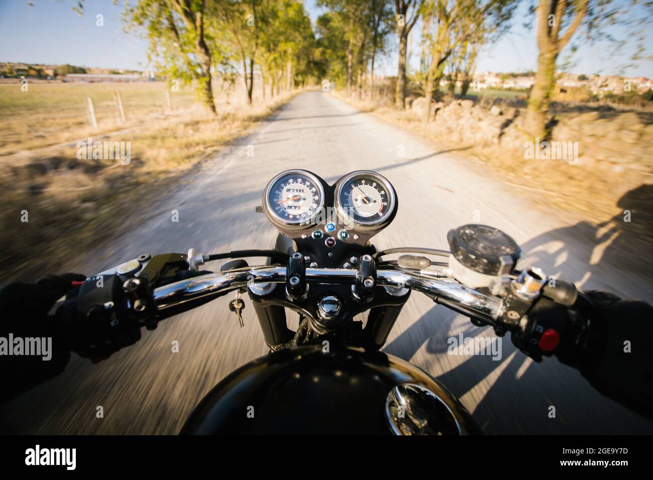 Back view of faceless fast racer riding motorbike through forest in ...