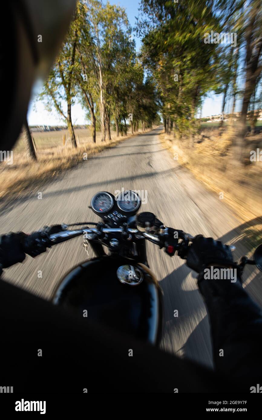 Back view of faceless fast racer riding motorbike through forest in ...