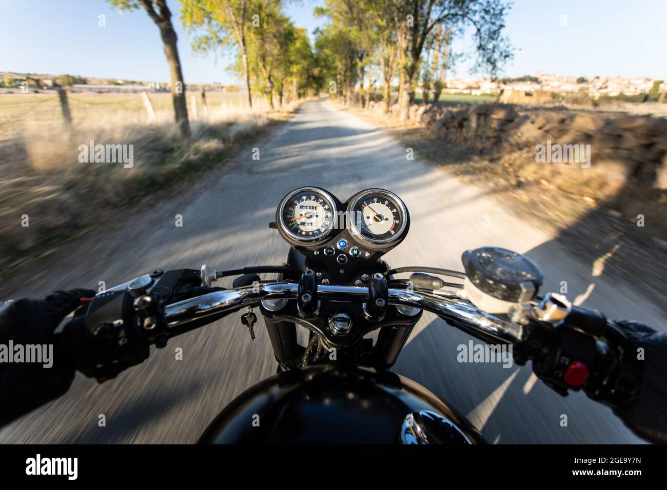 Back view of faceless fast racer riding motorbike through forest in ...
