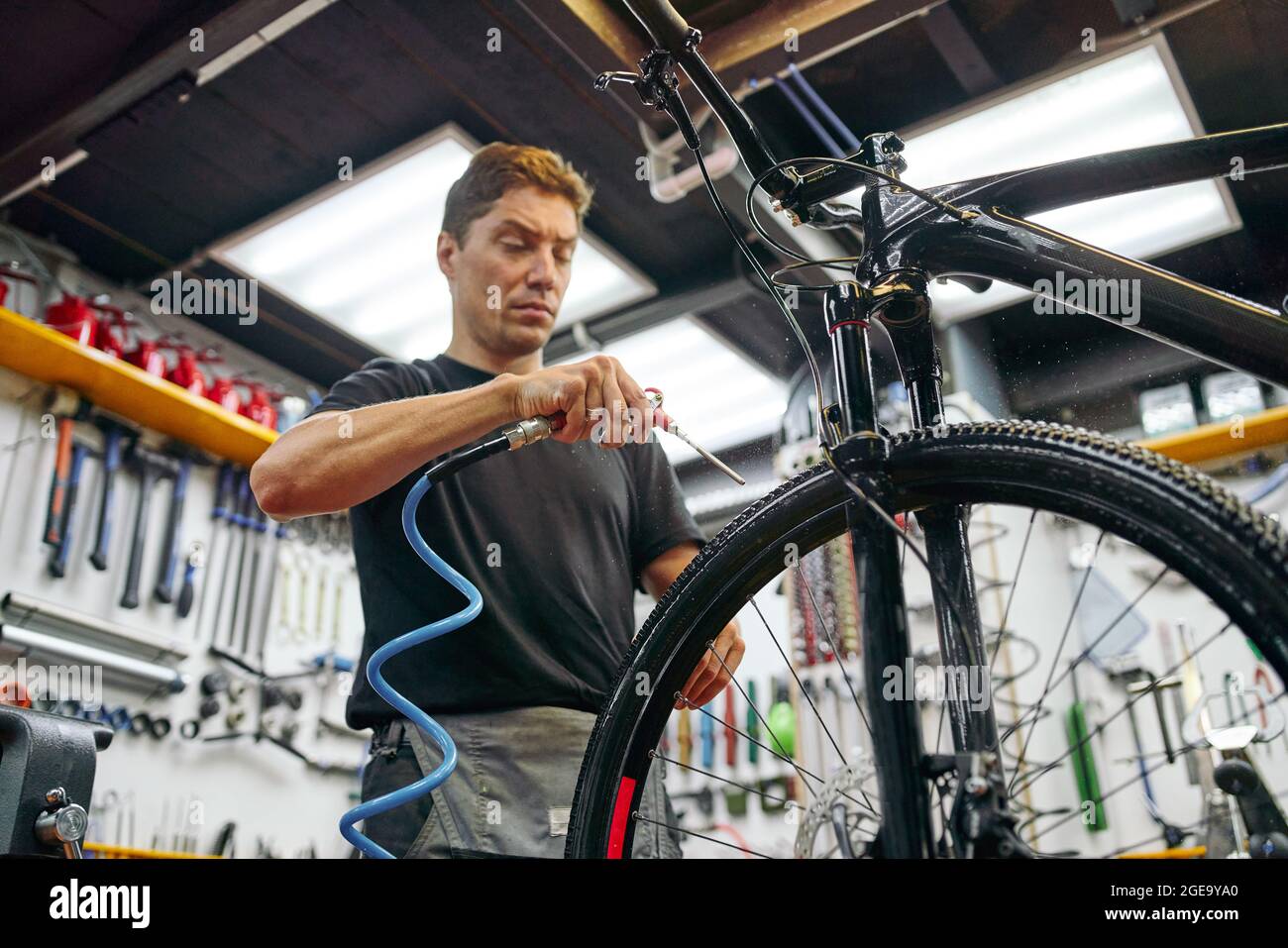 Low angle of male master using compressed air gun while removing dusk ...