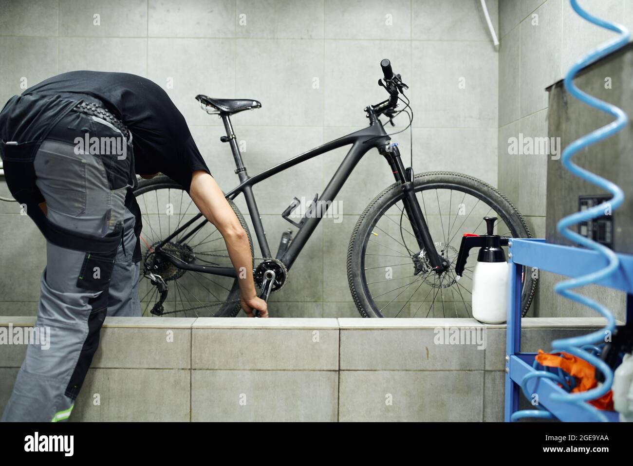 Unrecognizable male mechanic cleaning gear cassette of bicycle wheel ...