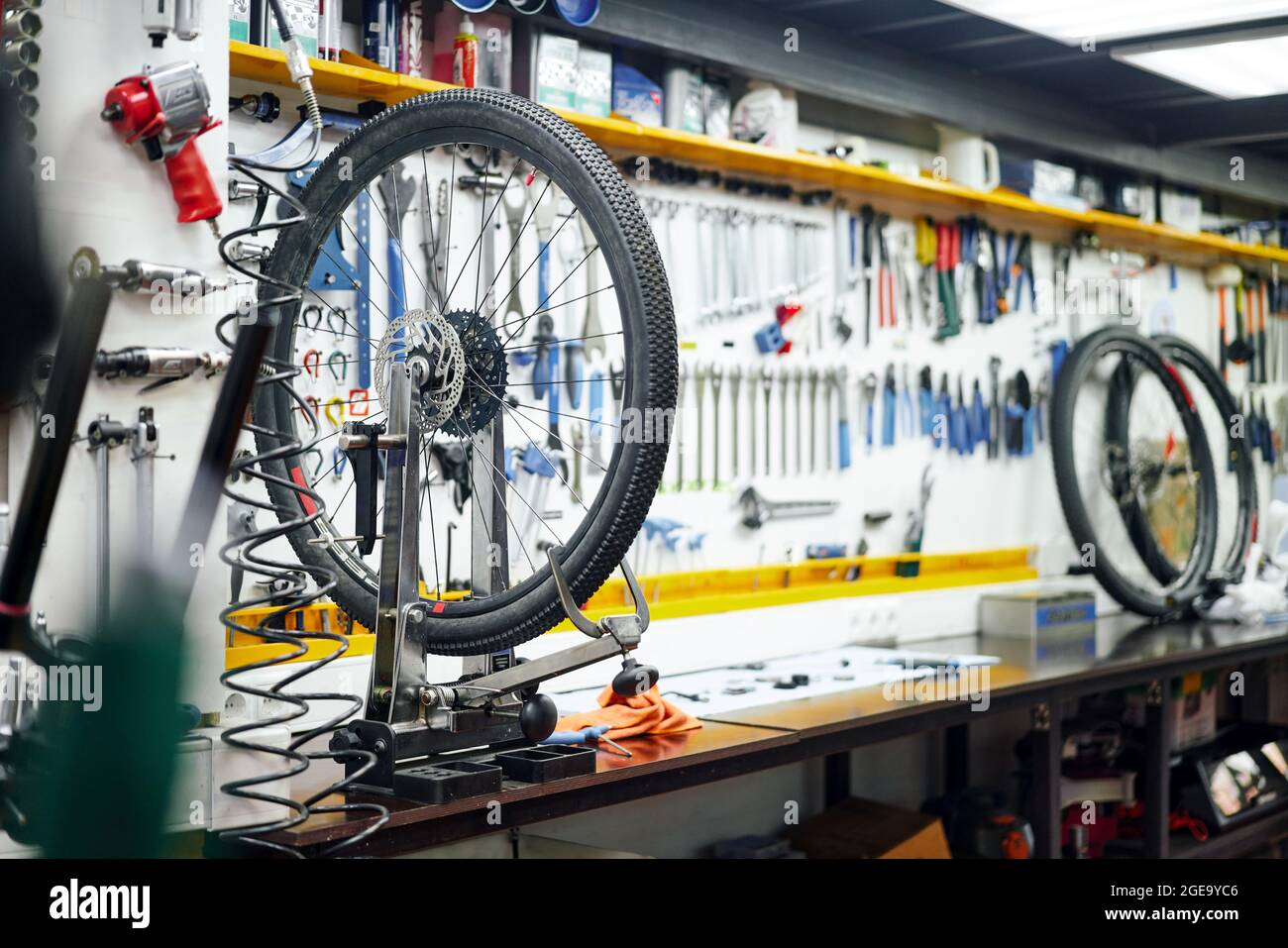 Modern bicycle attached to rack near wall with assorted instruments in ...