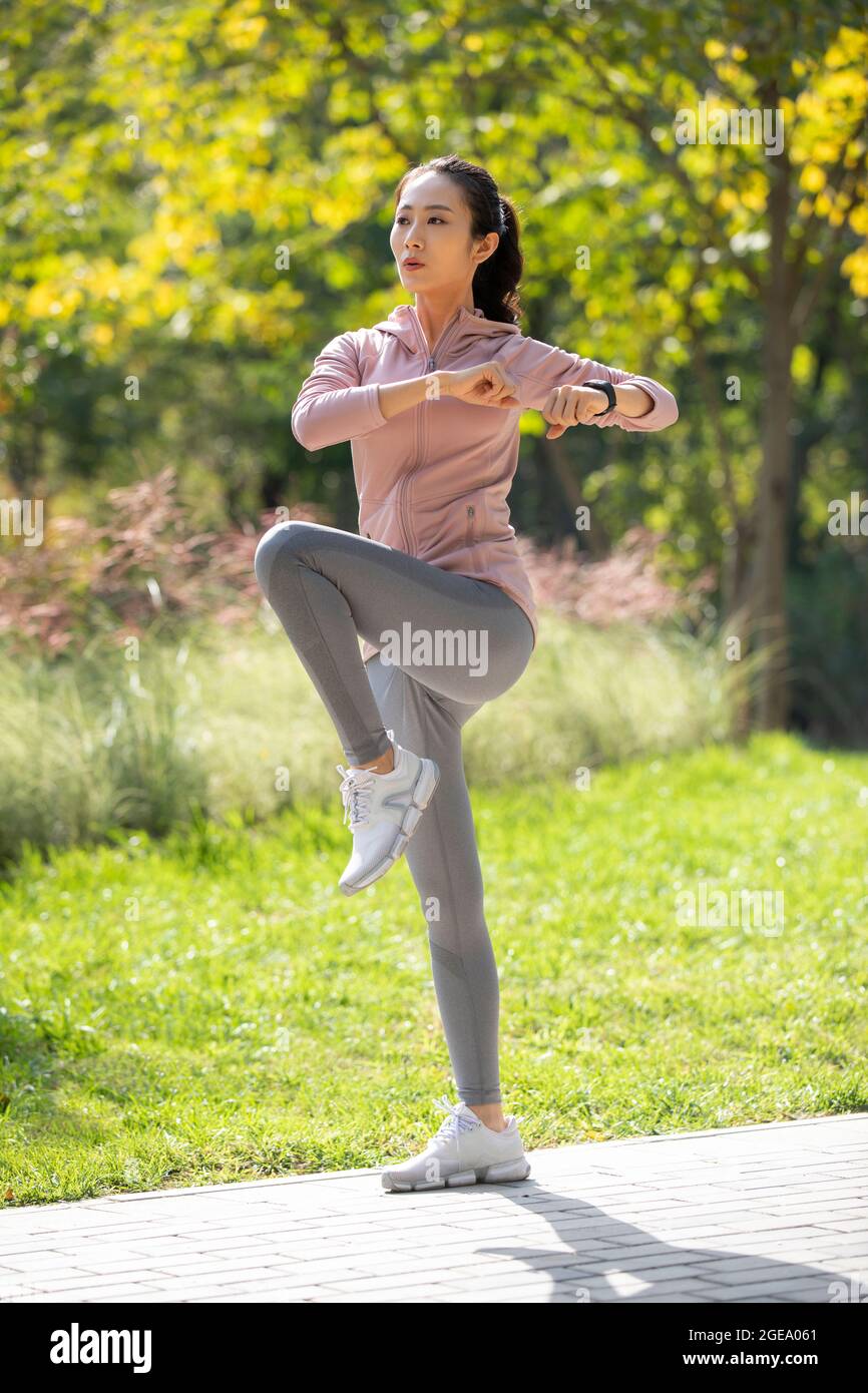 Young Chinese woman exercising in park Stock Photo - Alamy