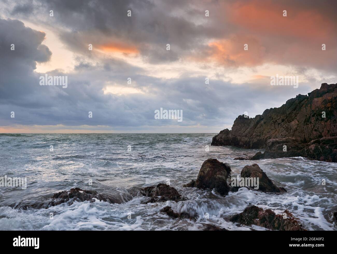 Rocks and rough sea at sunset Stock Photo - Alamy