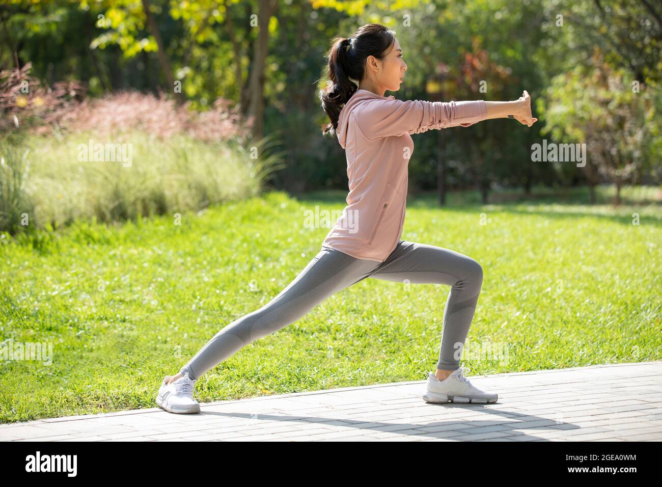 Young Chinese woman exercising in park Stock Photo - Alamy