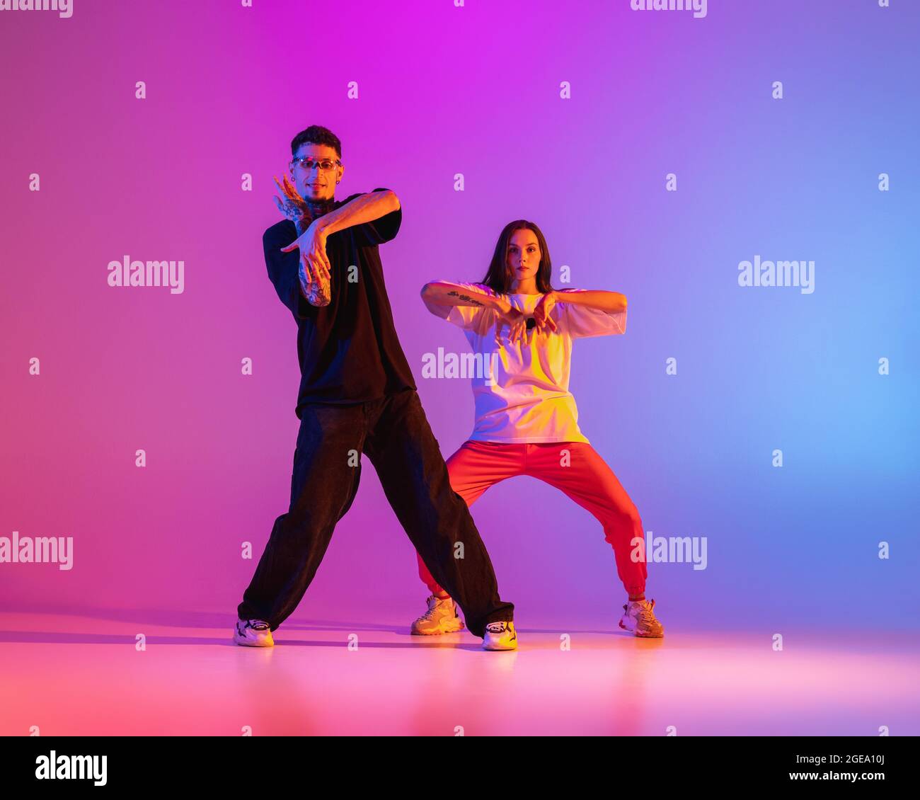 Two young people, guy and girl in casual clothes dancing contemporary ...