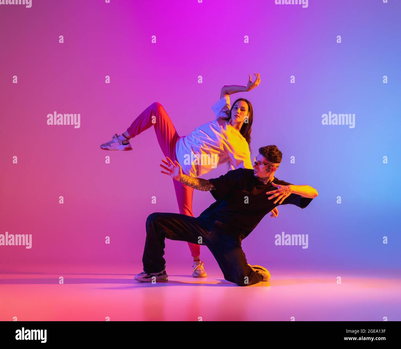 Two young people, guy and girl in casual clothes dancing contemporary ...