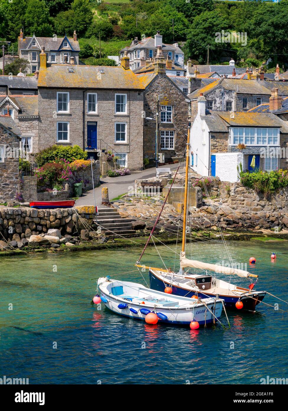 Fishing boats moored in the harbour of a traditional Cornish village ...