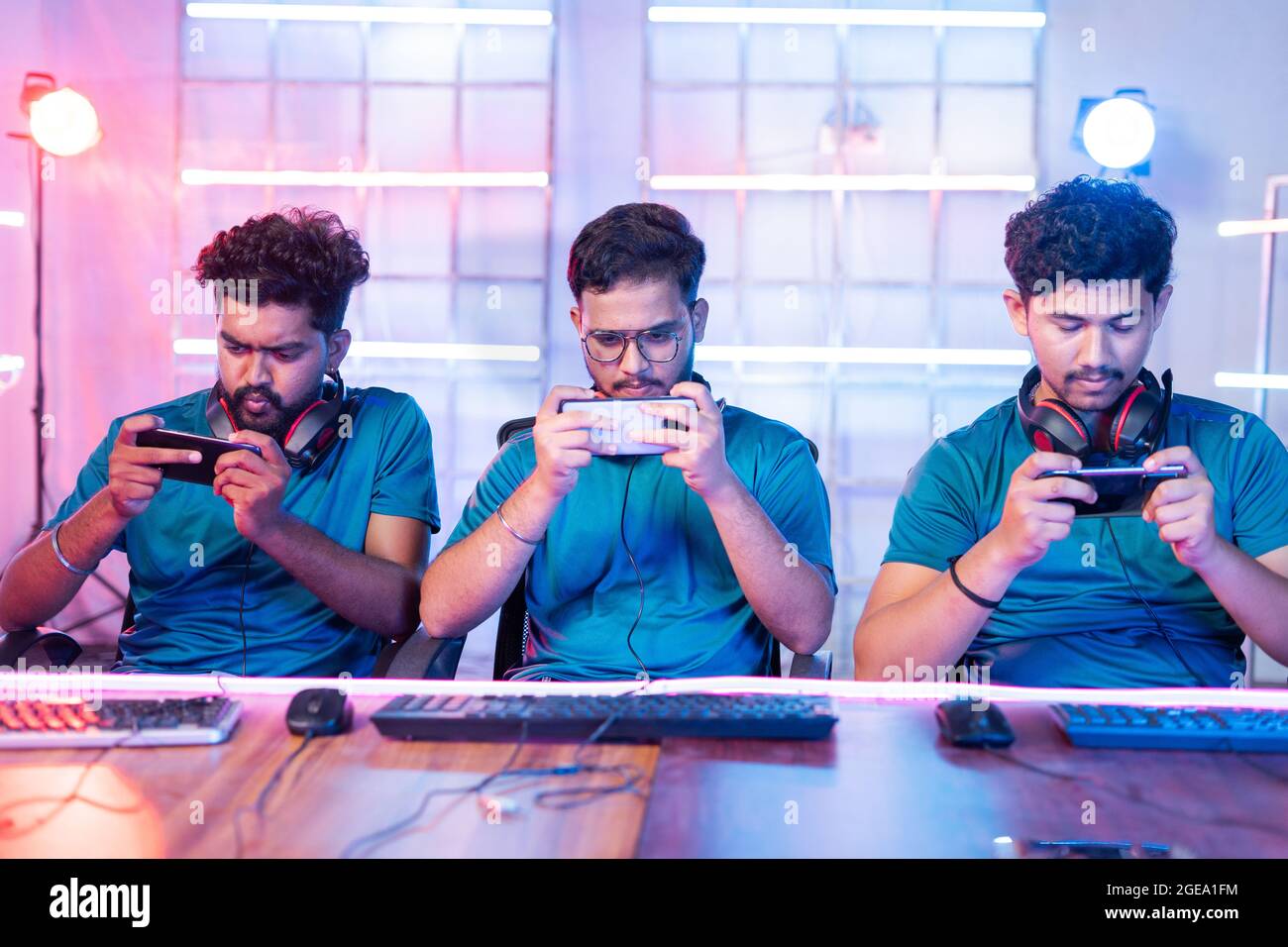 Front view of Team of young professional gamers seriously playing of ...