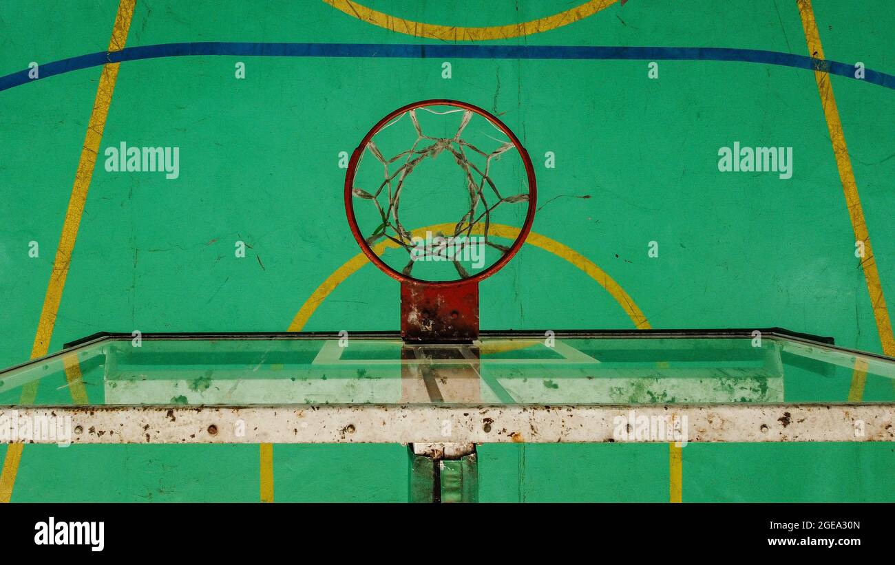 Rusty and weather-spotted basketball hoop seen from above, the green ...