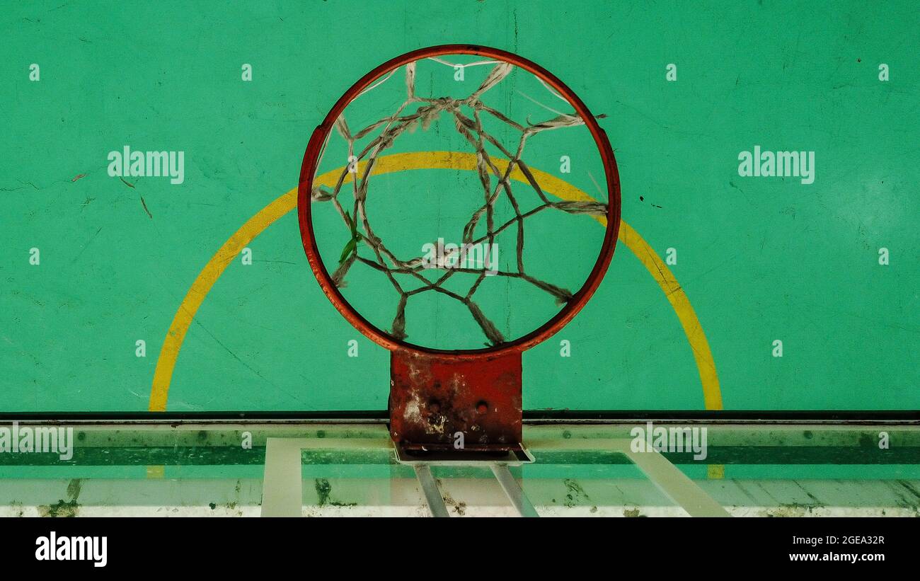 Rusty and weather-spotted basketball hoop seen from above, the green ...