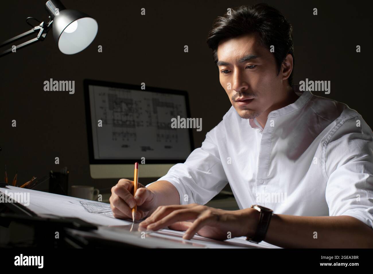 Chinese designer working on construction plan Stock Photo - Alamy