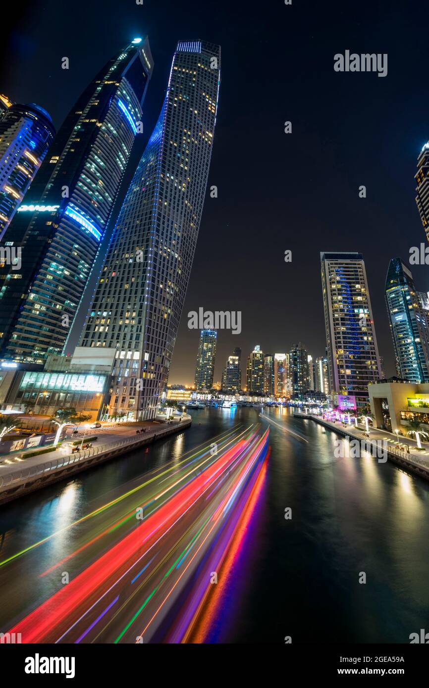 The colourful light trail from a passing Arabic dhow winds through the ...