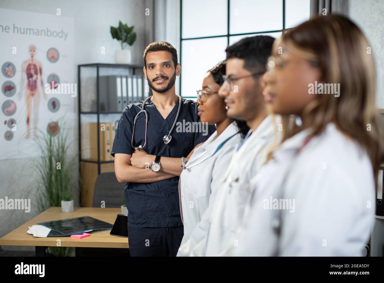 Profile view of multiracial group of medical interns in lab coats ...