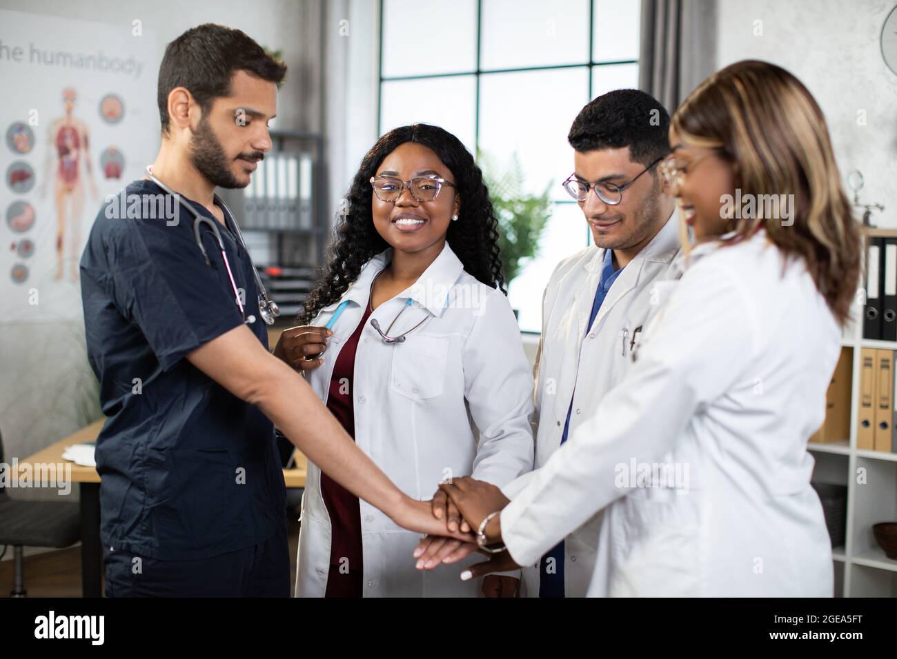 Unity and teamwork concept where four doctors and nurses in a medical ...
