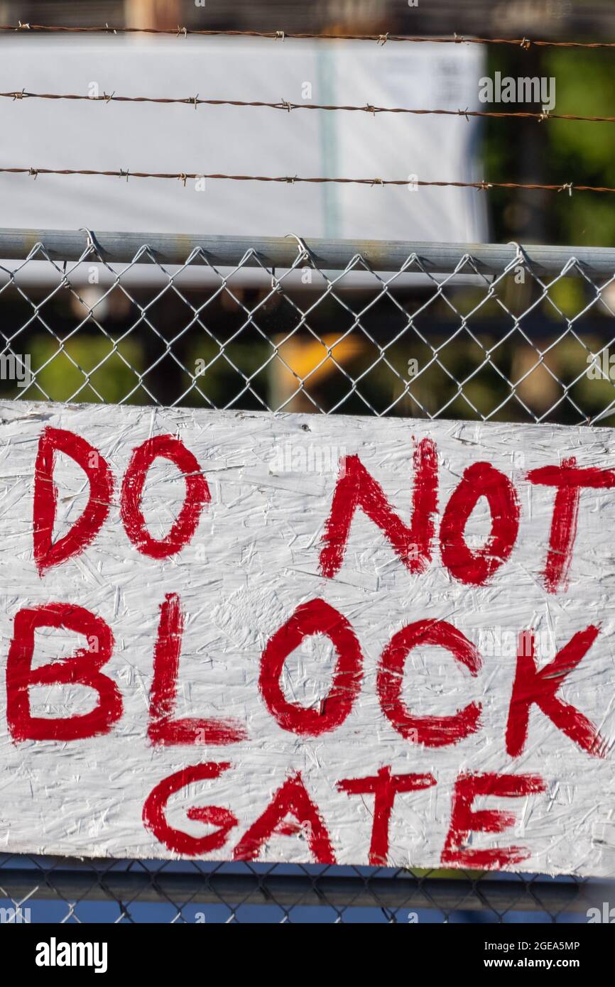 red sign reads do not block gate Stock Photo - Alamy
