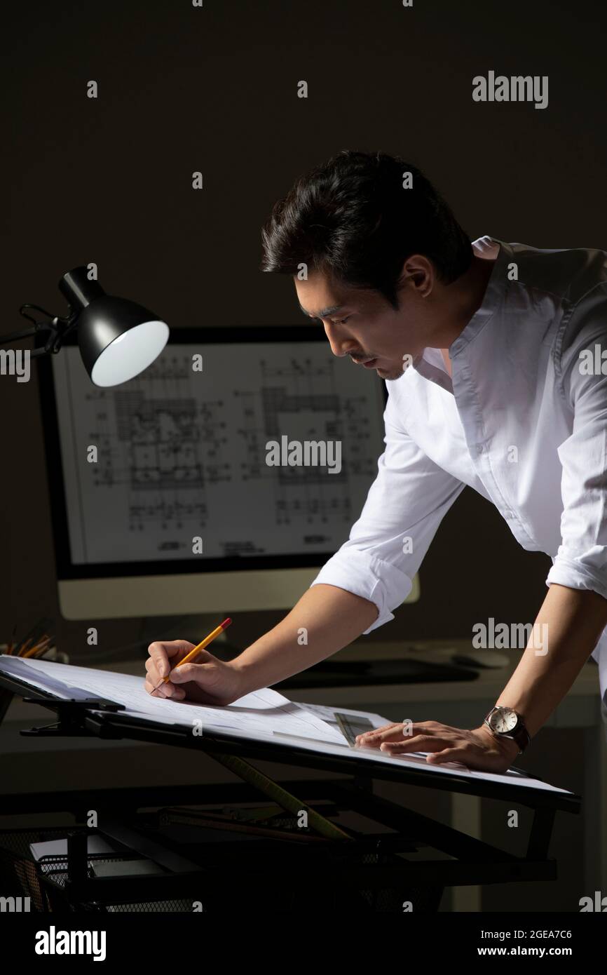 Chinese designer working on construction plan Stock Photo - Alamy