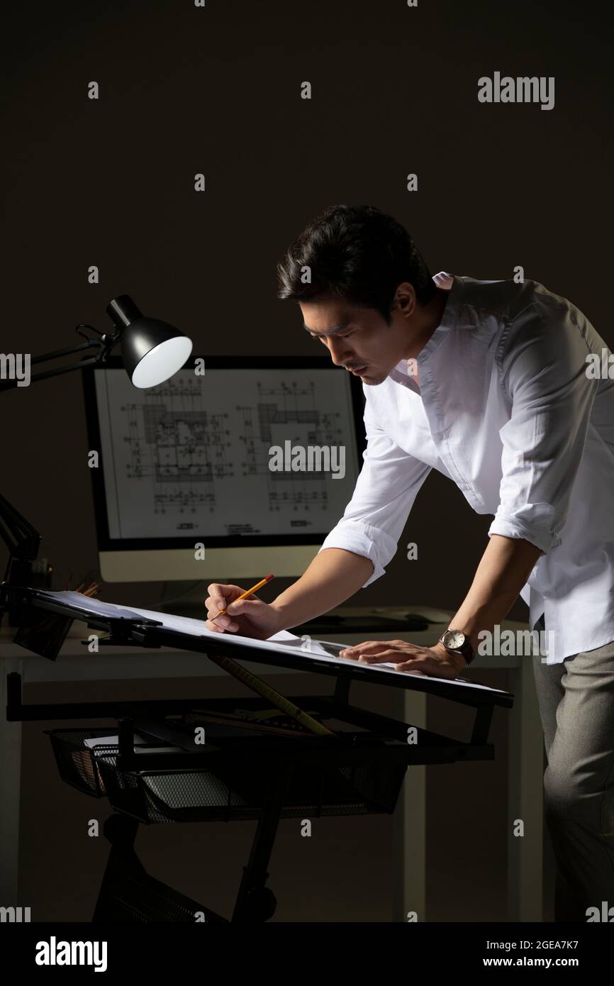 Chinese designer working on construction plan Stock Photo - Alamy