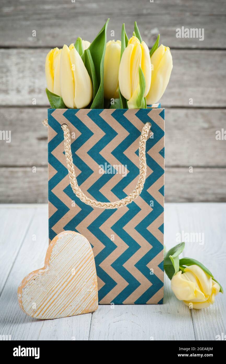 Spring greeting card with yellow tulips in kraft package and decorative ...