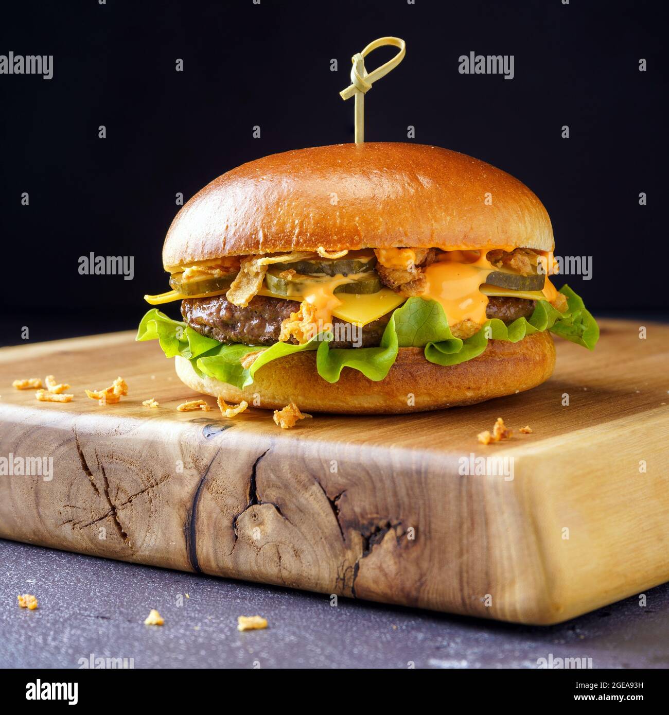 The Cheeseburger on a thick light wooden stand Stock Photo - Alamy