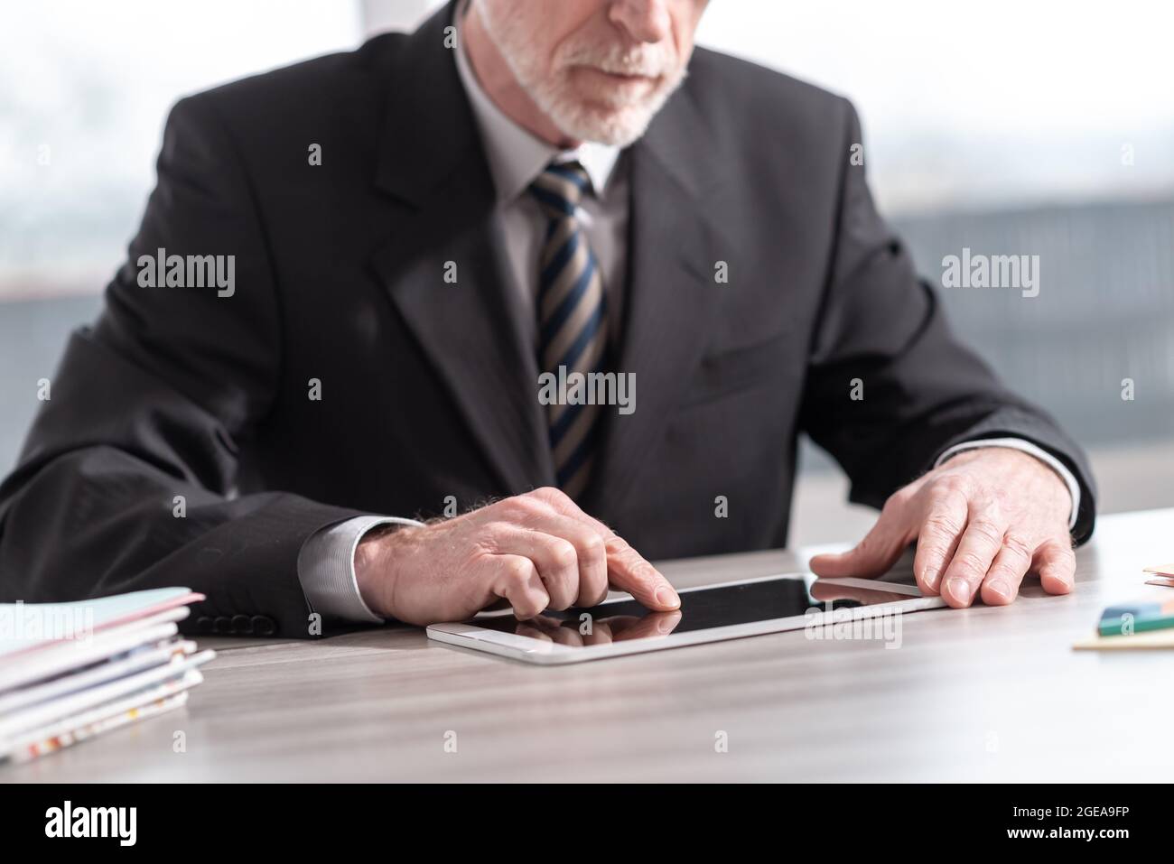 Senior businessman using a digital tablet in office Stock Photo - Alamy