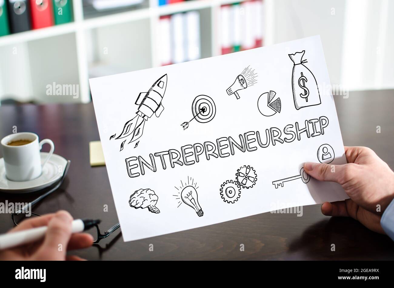 Hand holding a paper showing entrepreneurship concept Stock Photo - Alamy