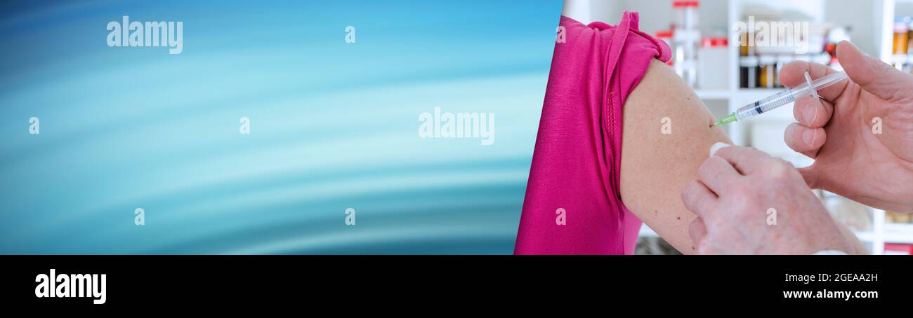 Doctor giving an injection to his patient in medical office; panoramic ...