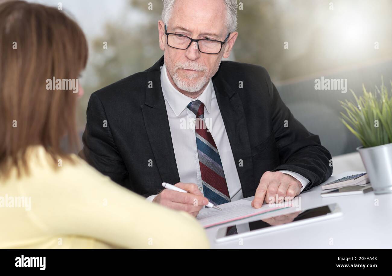 Financial consultant giving advices to female client, light effect ...