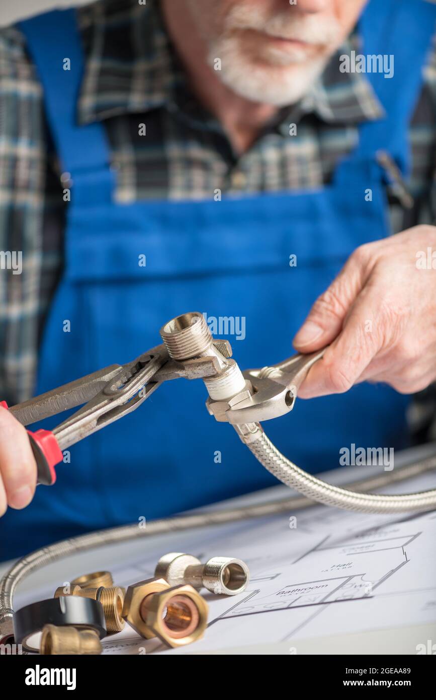 Plumber screwing a plumbing fitting on a pipe Stock Photo - Alamy