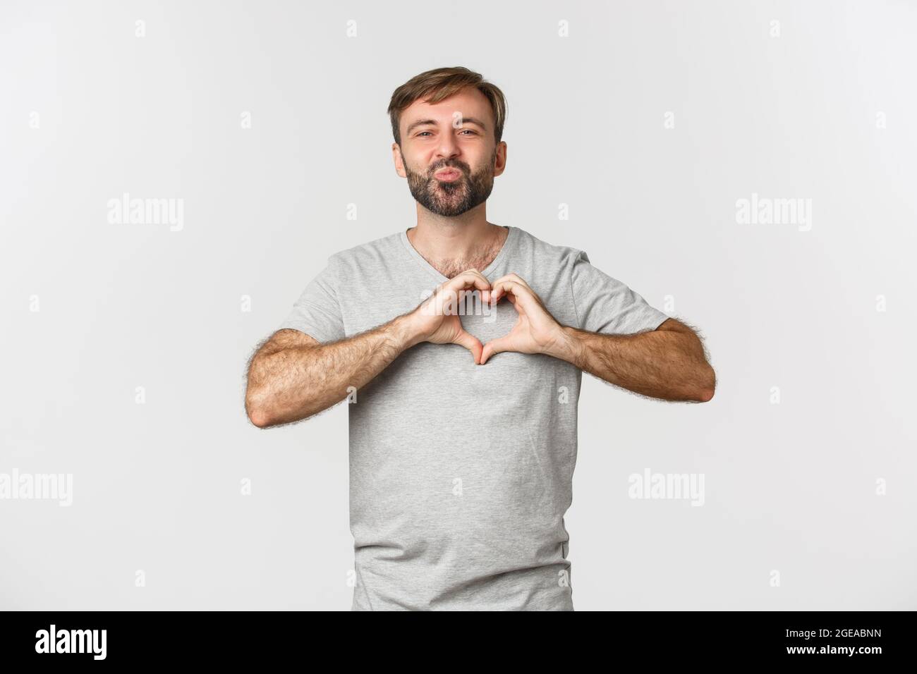 Portrait of handsome smiling man with beard, showing heart sign ...
