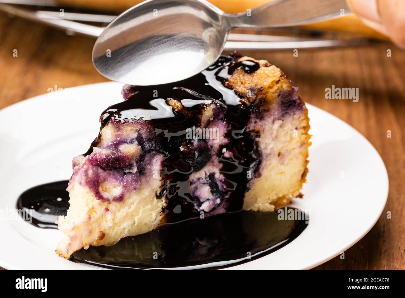 Using metal spoon taking a bite from a piece of homemade blueberry and ...
