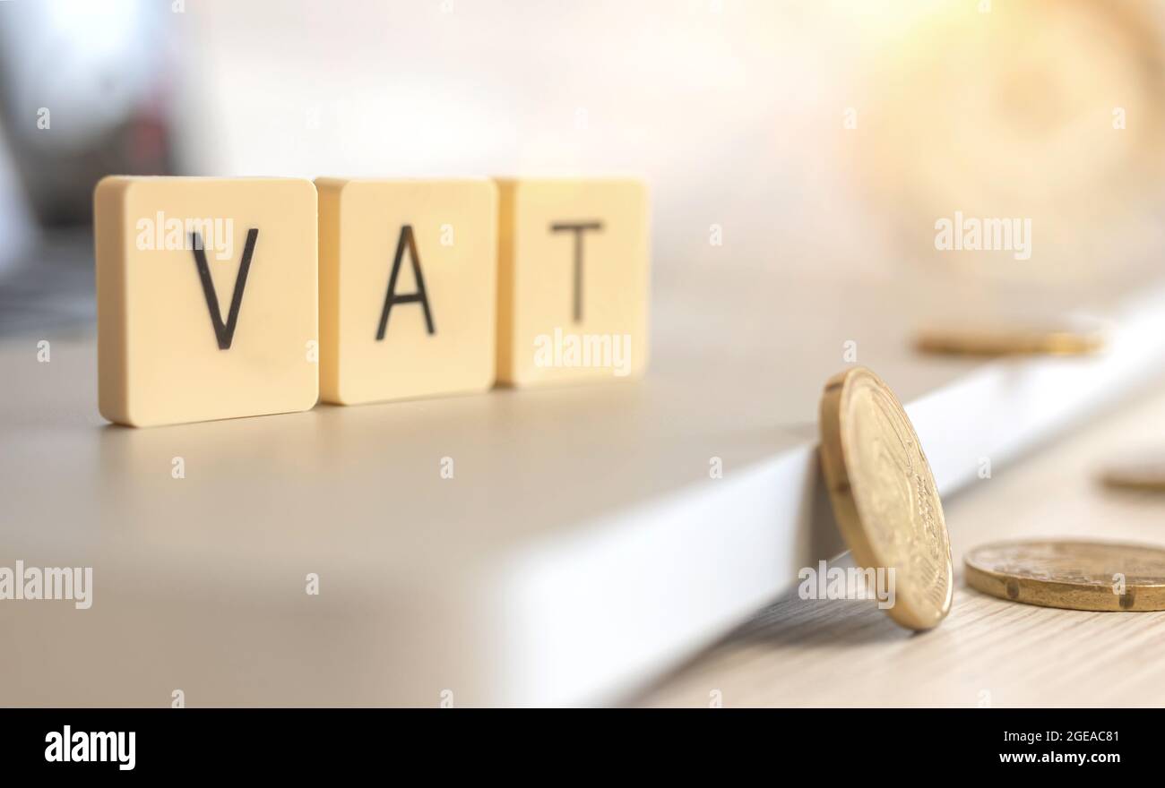 VAT concept background. Word VAT and coins on desktop. Business and ...
