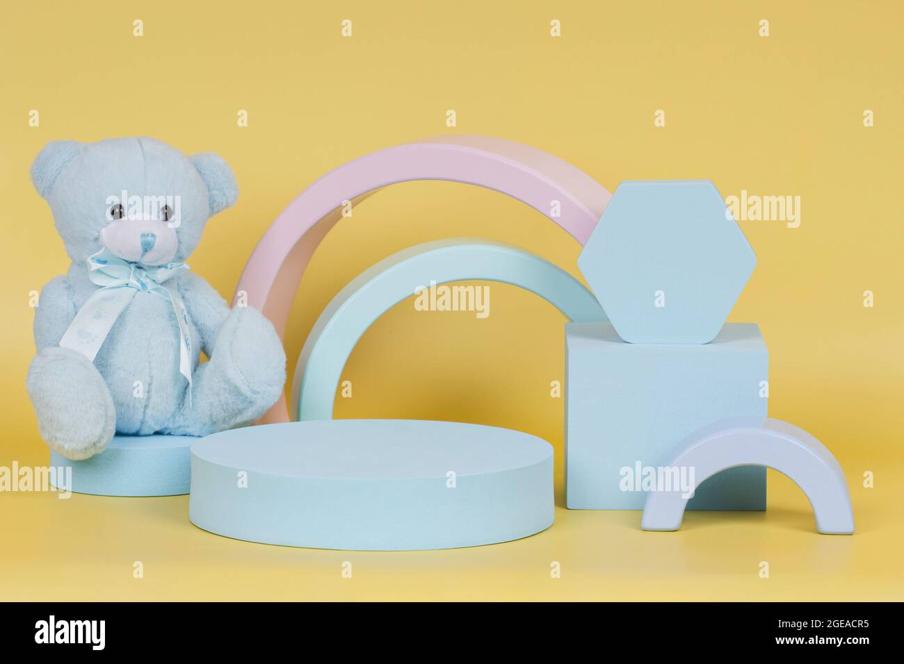 Geometric shapes podium platforms with wooden toys and teddy bear on ...