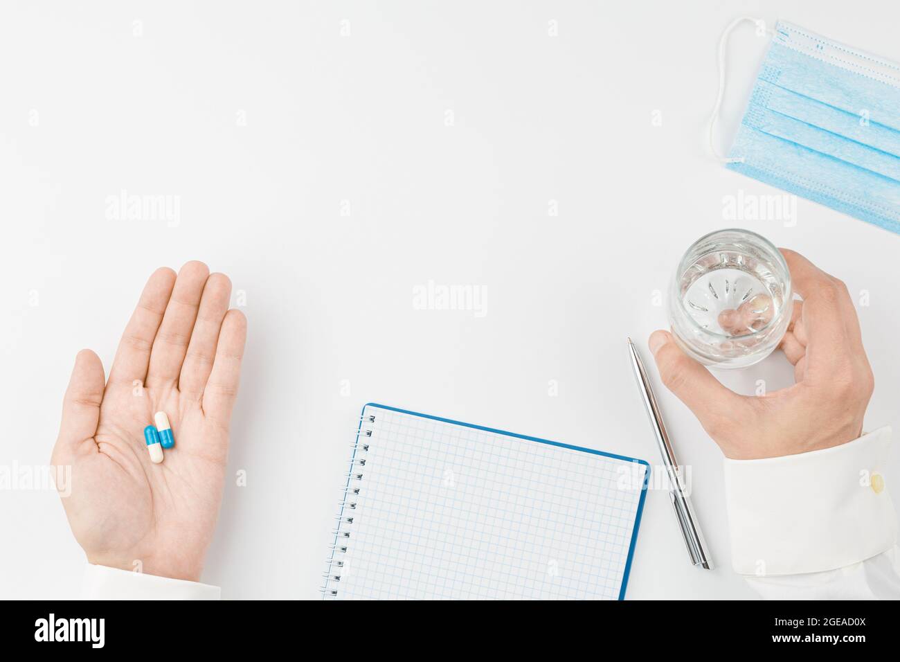 Doctor offers pills and a glass of water Stock Photo - Alamy