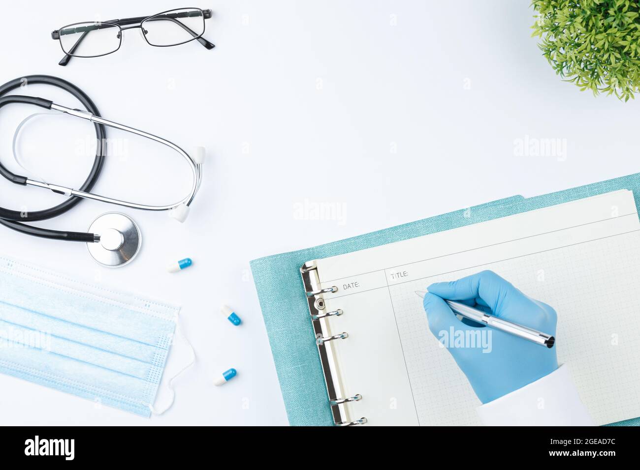Doctor at his desk writes in a notebook Stock Photo - Alamy