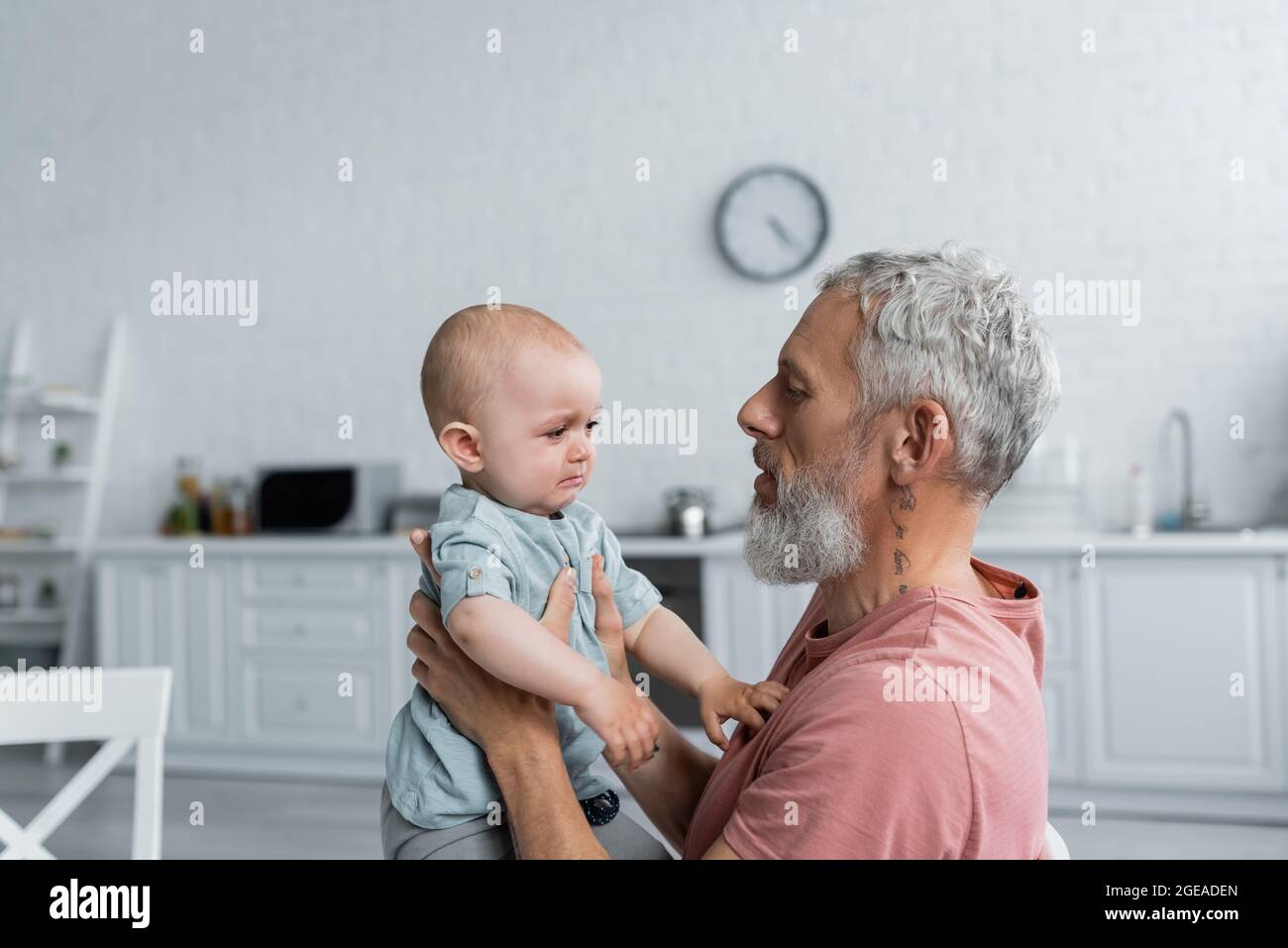 Man holding upset baby daughter at home Stock Photo - Alamy