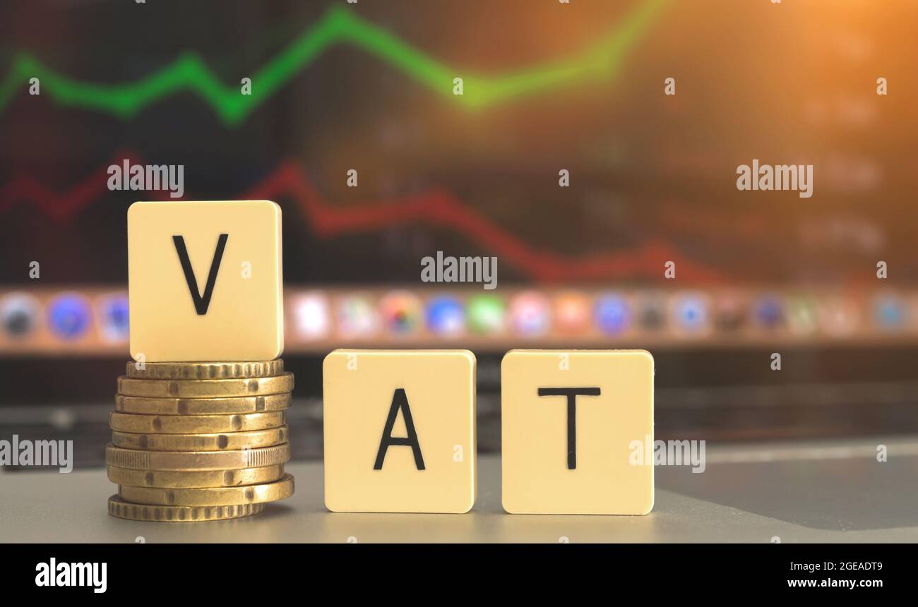 Coins stack with wooden block and word VAT. Financial amagement and ...