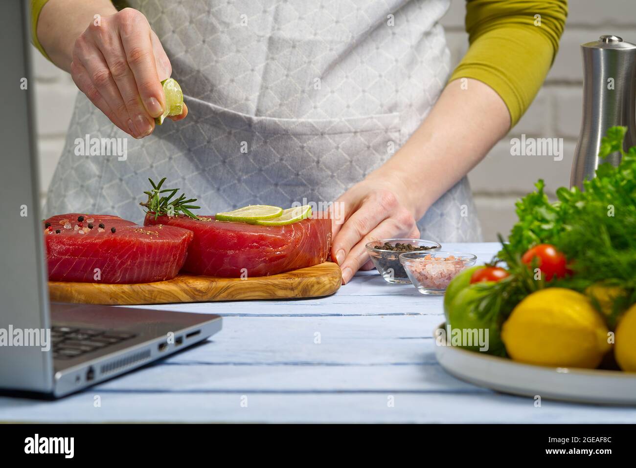 cooking and computer laptop concept. cooking woman in kitchen with pc ...