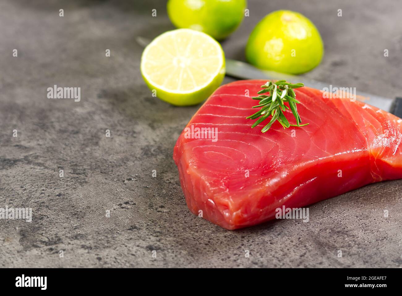 Raw tuna fillet steak with dill, lemon and spices in olive cutting ...