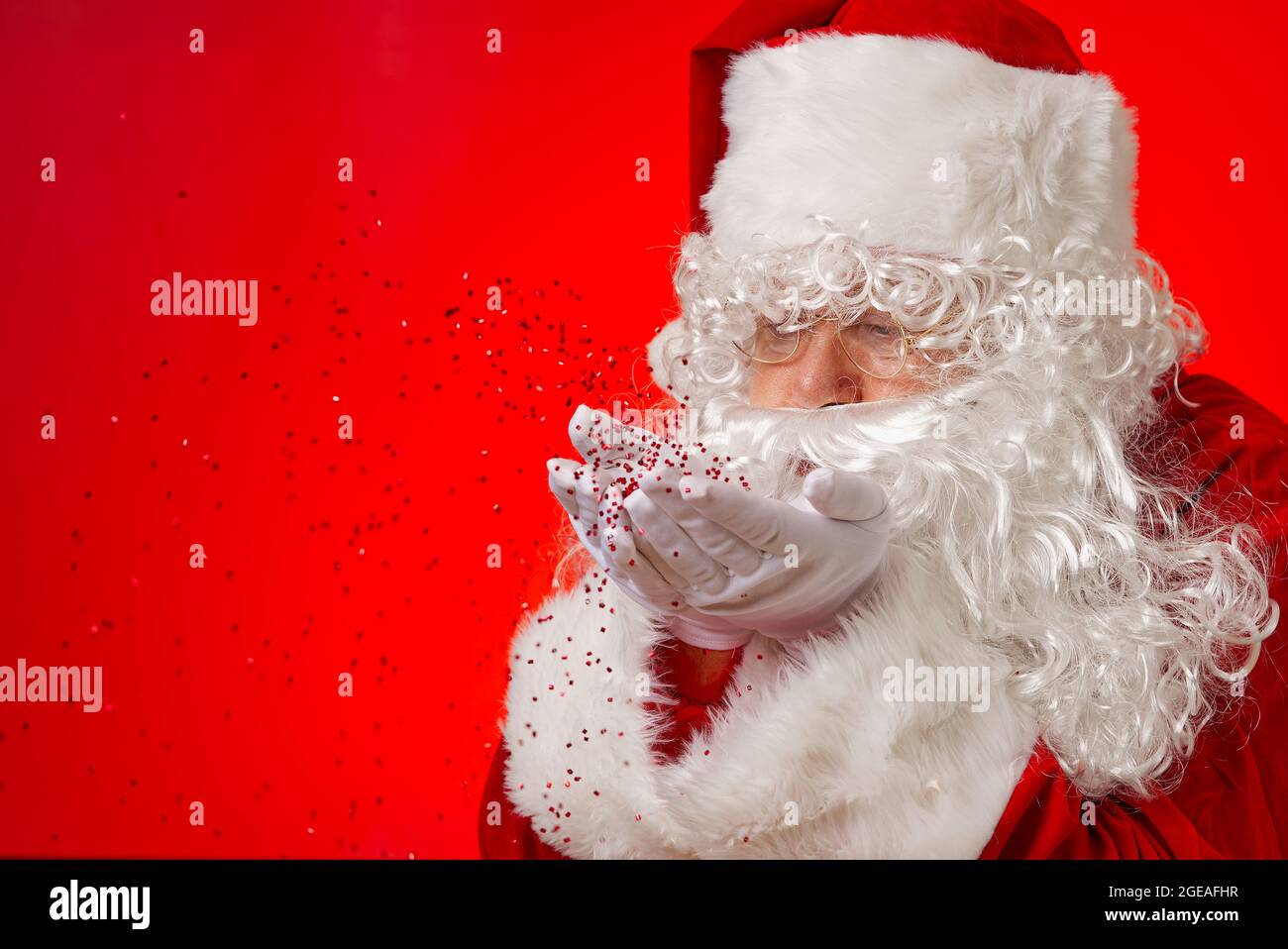 santa claus blowing red glitter confetti from hands Stock Photo - Alamy