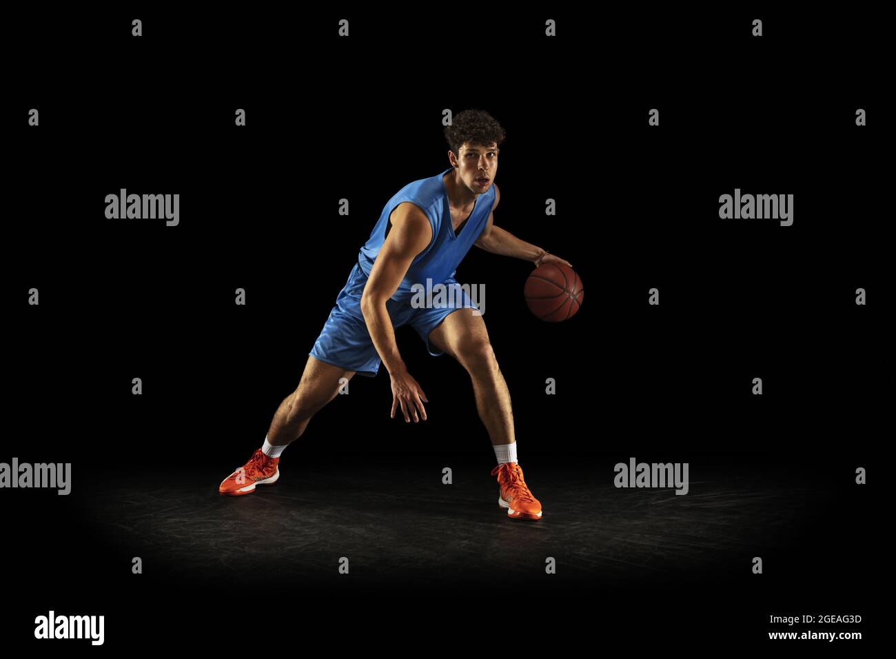 One young caucasian professional basketball player exercising with ball ...