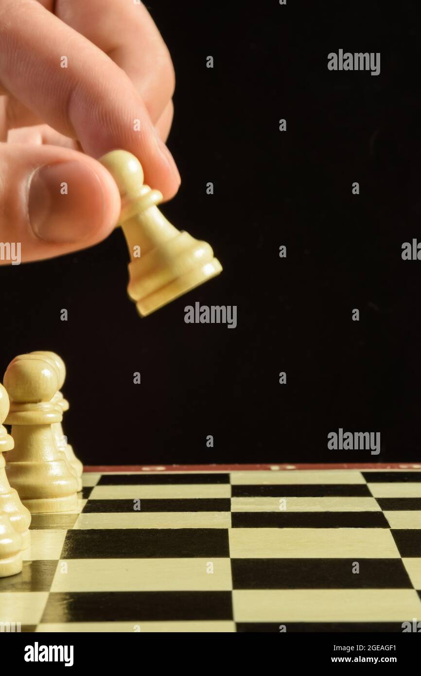 On the chessboard are left white chess wooden pieces Pawns. Above them ...