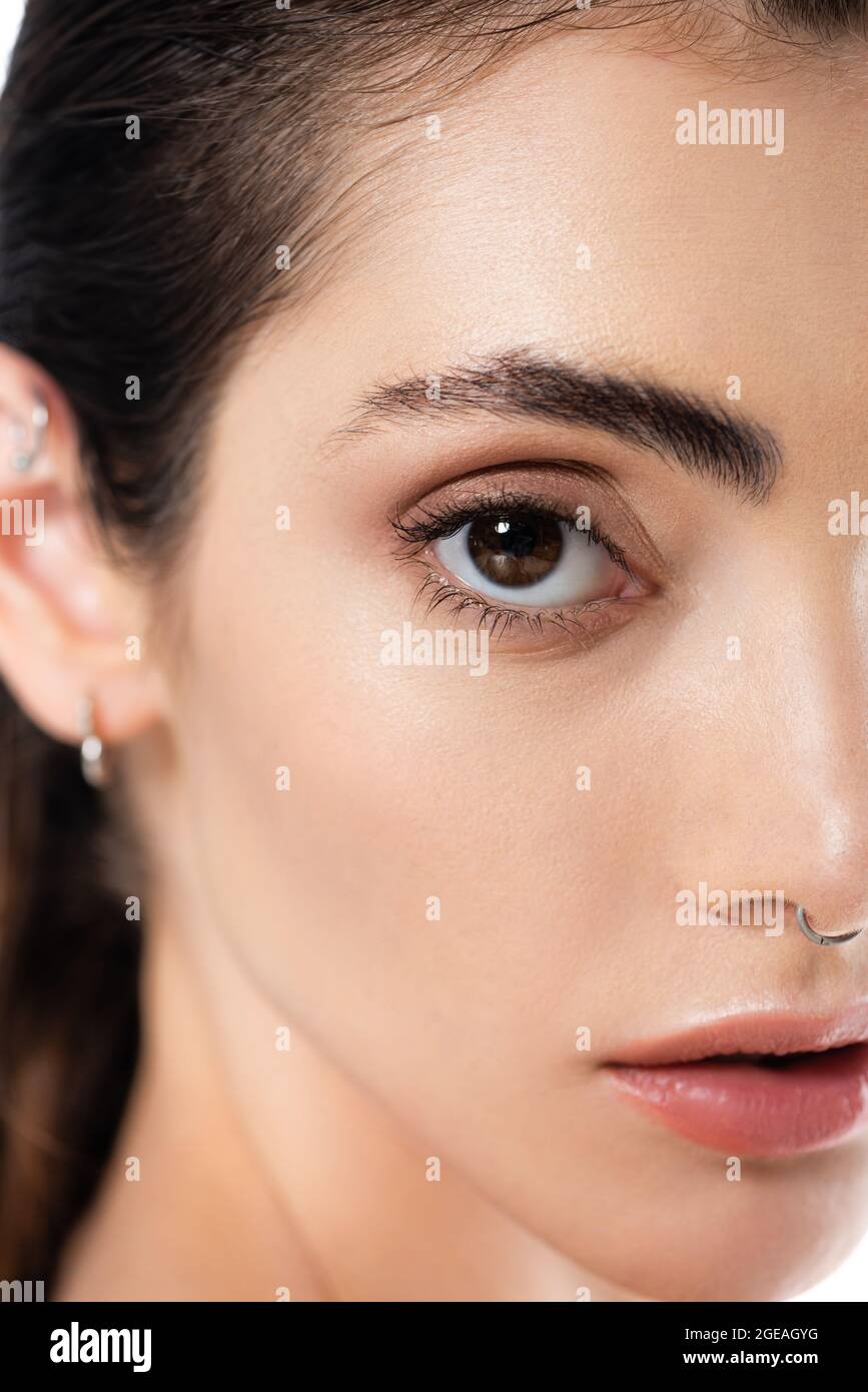 cropped view of young pierced woman with perfect skin looking at camera ...