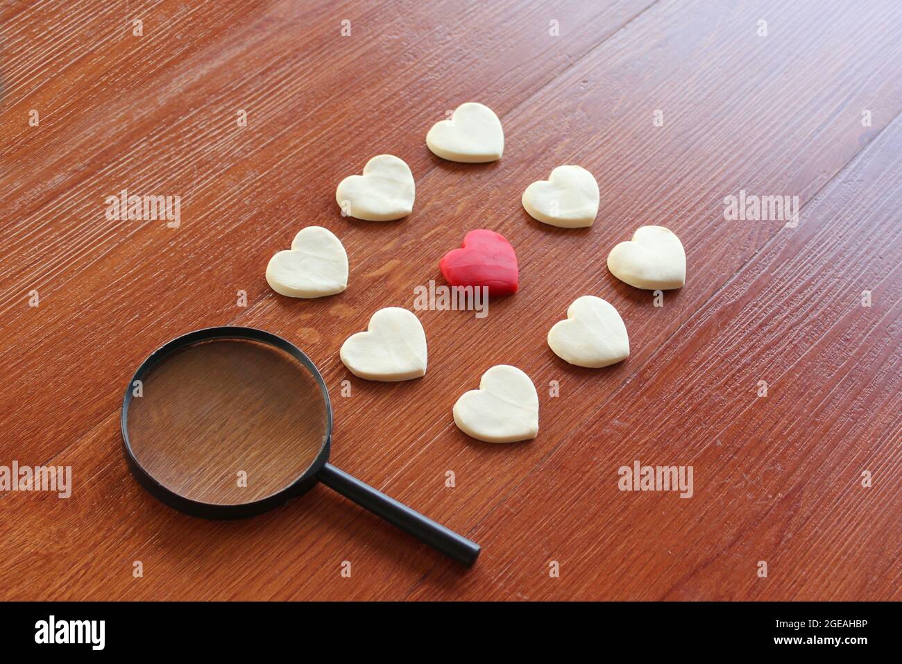 Magnifying glass, red heart and white heart. Finding true love ...
