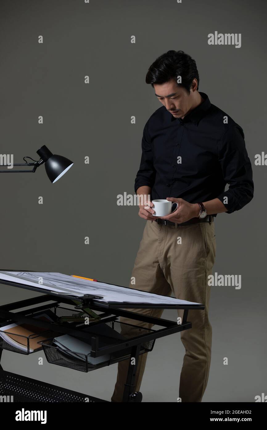 Chinese designer working on construction plan Stock Photo - Alamy
