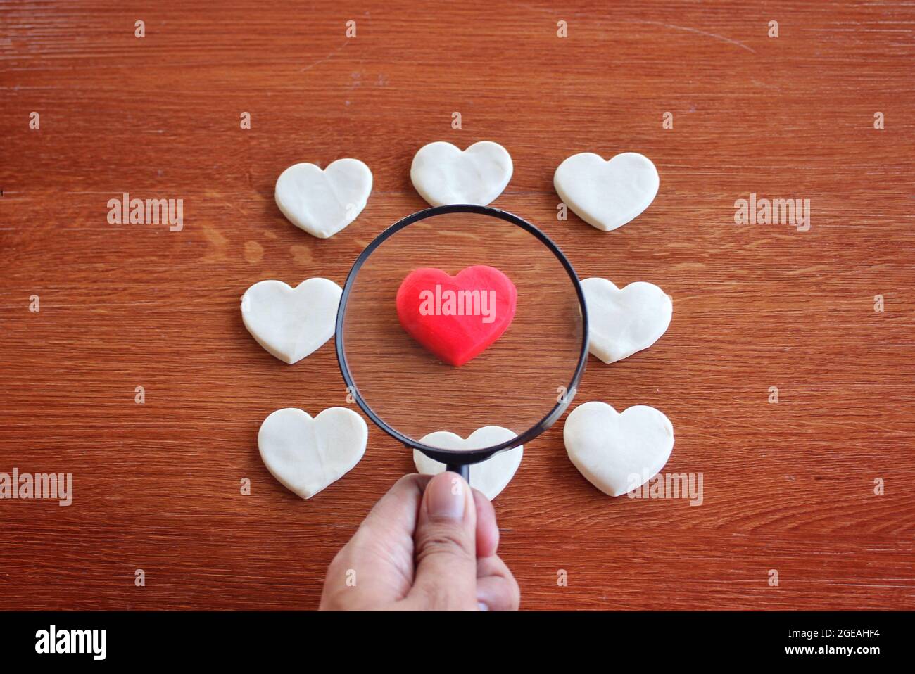 Magnifying glass, red heart and white heart. Finding true love ...